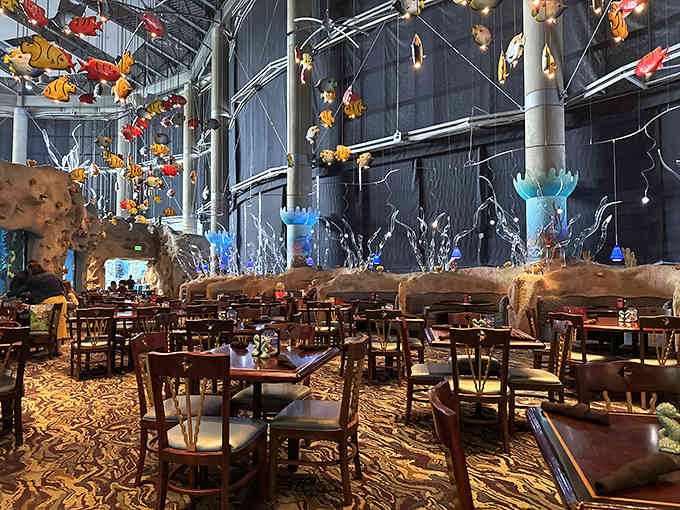 Colorful fish sculptures swim overhead while real marine life glides past in this theatrical dining room.