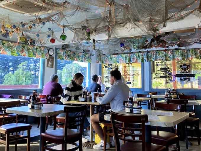 Fishing nets and glass floats transform the ceiling into an underwater fantasy that's pure California coastal charm.