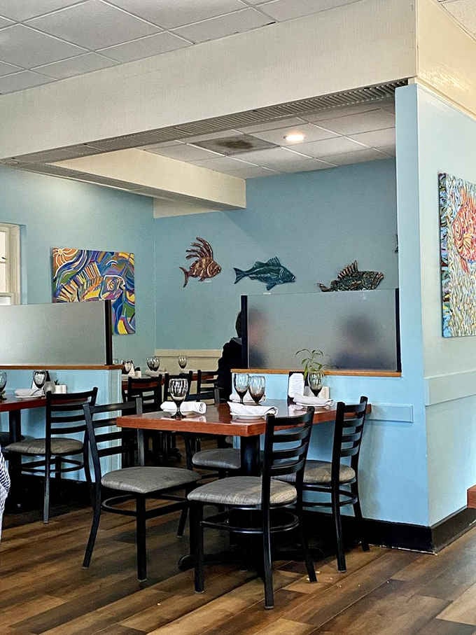 Colorful fish art and calming blue walls create the perfect backdrop for your upcoming seafood feast.