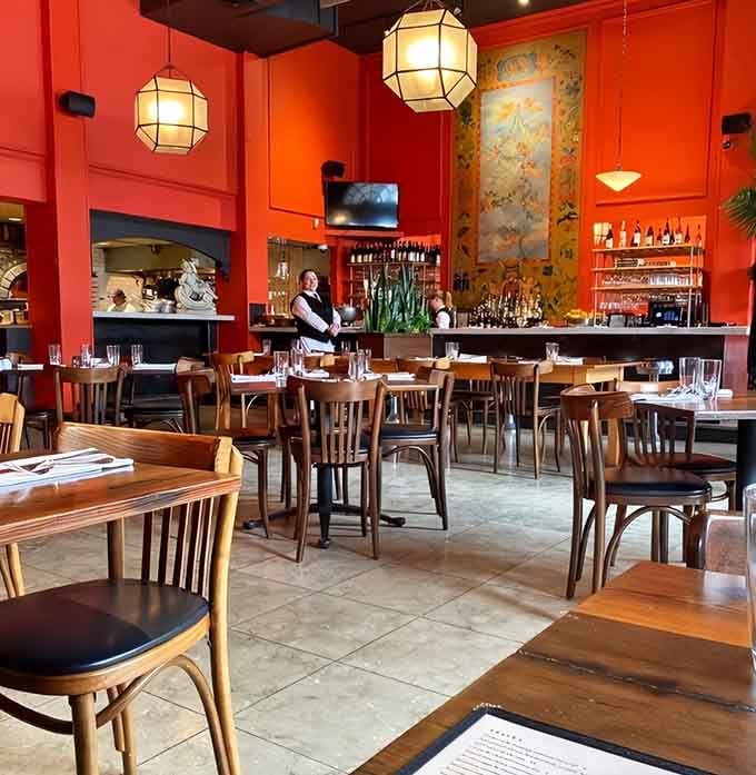 Warm orange walls and vintage Italian posters create an atmosphere that's equal parts sophisticated and genuinely welcoming.