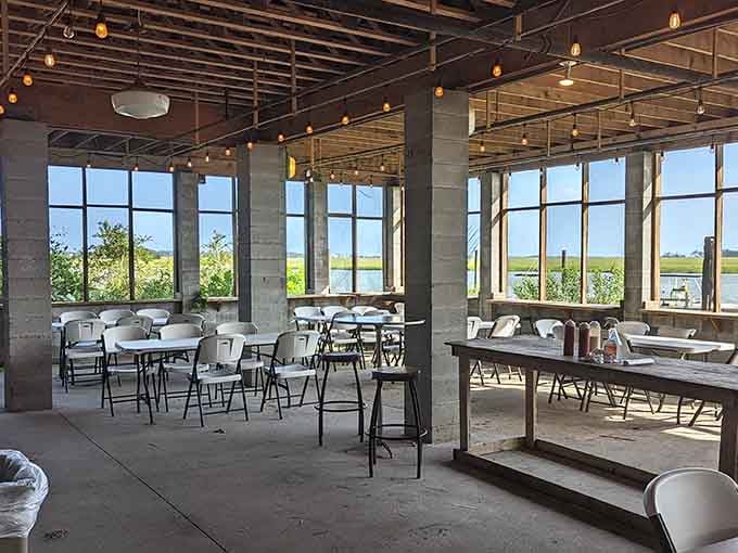 Floor-to-ceiling windows frame the marsh like nature's own IMAX screen, proving that the best dinner theater doesn't need a stage.