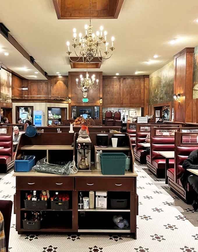 Classic chandeliers and burgundy booths create an atmosphere where every meal feels like a special occasion worth celebrating.