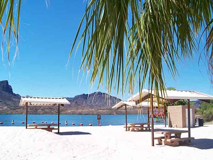 Your own shaded picnic spot awaits, where sandy beaches meet desert mountains in perfect harmony.