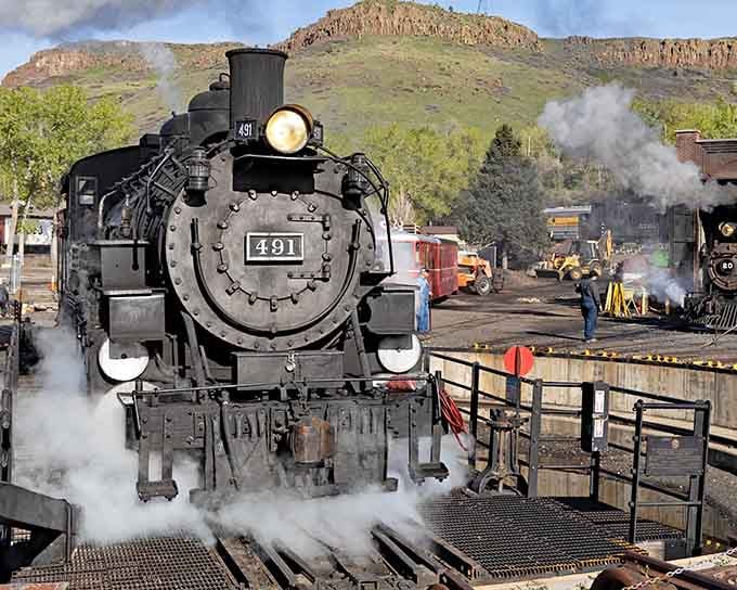 Steam billows from locomotive 491 like a dragon waking up, pure mechanical poetry against Colorado's foothills.