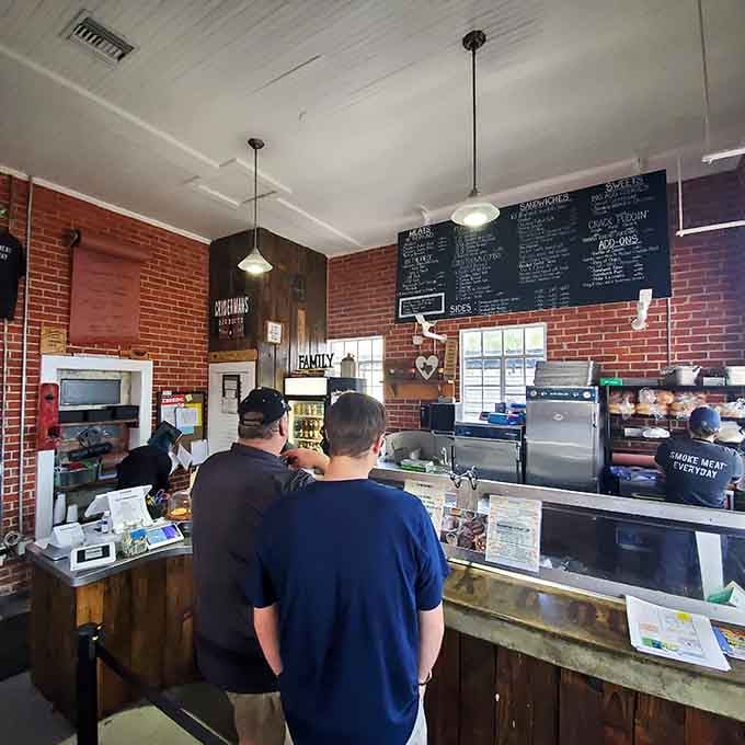 That chalkboard menu holds the keys to smoked meat paradise, and your stomach already knows it.