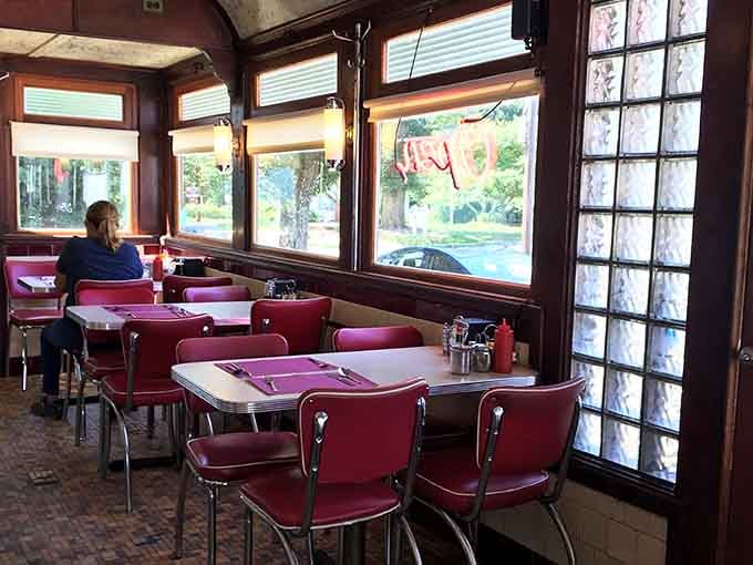 Burgundy vinyl booths and natural light streaming through those windows make every meal feel like Sunday morning.
