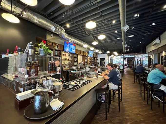 Industrial chic meets Southern hospitality with exposed ductwork, a gleaming bar, and bourbon bottles lined up like soldiers at attention.