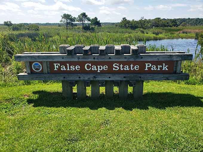 The journey begins here, where a simple wooden sign marks the gateway to Virginia's most wonderfully inconvenient beach adventure.