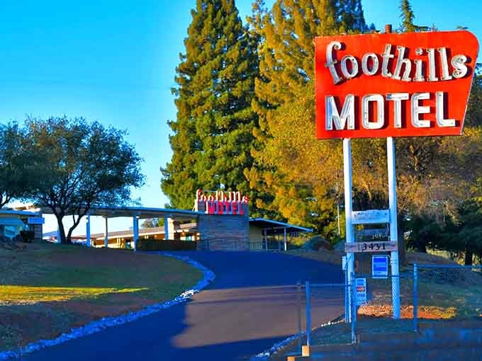 The vintage signage stands tall against golden hour skies, promising retro charm just up the driveway ahead.