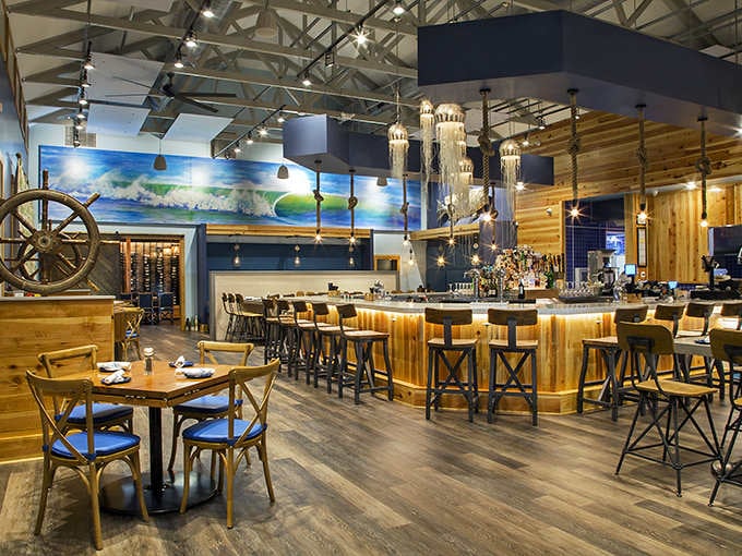 Inside, nautical elegance meets modern comfort where jellyfish chandeliers float above like something from a Jacques Cousteau fever dream.