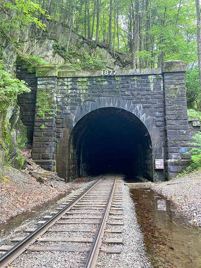 The eastern portal stands like a gateway to another era, where progress came with an unthinkable price tag.