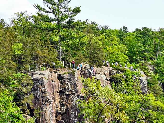 Hikers gather atop these weathered cliffs, drawn like moths to the flame of geological wonder and Instagram opportunities.