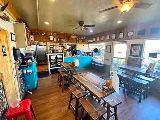 Cozy wooden tables and turquoise accents create the perfect setting for your upcoming burger adventure.