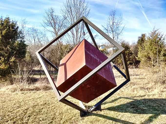 A geometric cube balances impossibly on one corner, defying gravity like a Rubik's Cube that solved itself.