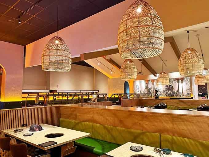 Those woven pendant lights and plush booths create an atmosphere that says "fancy" but whispers "come get messy with some BBQ."