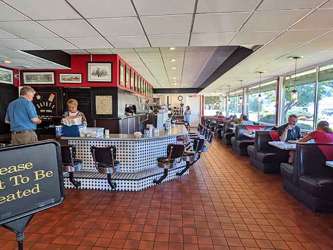 Classic black booths meet checkered counter charm in a space where retro vibes feel perfectly, wonderfully right.