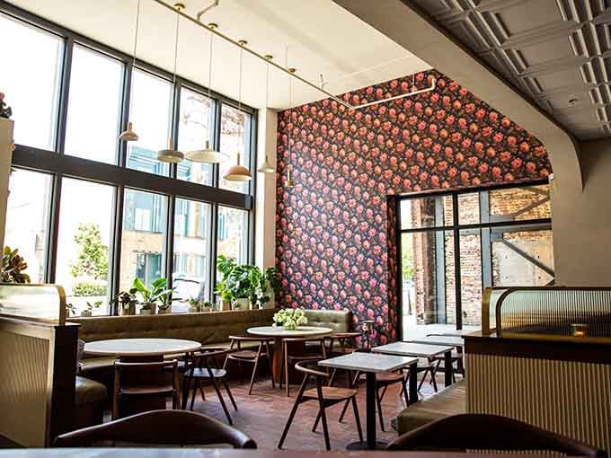 Floor-to-ceiling windows bathe this dining room in golden light that makes everything look Instagram-worthy.