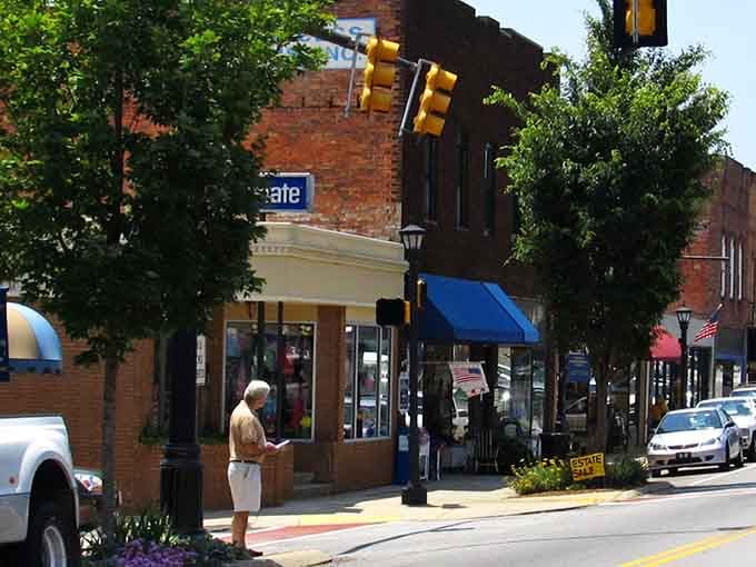 Historic brick storefronts line streets where antique hunters walk slower than usual, scanning every window for hidden treasures.