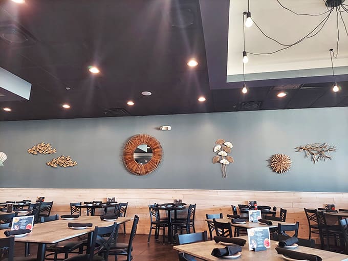 Coastal-inspired decor with artistic touches creates an atmosphere where casual comfort meets sophisticated dining in perfect harmony.