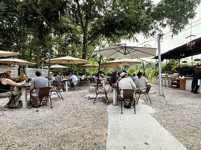 Gravel paths, string lights, and happy diners create the kind of outdoor dining scene that makes air conditioning seem overrated.