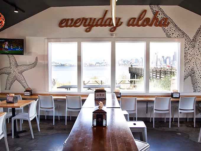 Floor-to-ceiling windows frame Elliott Bay views while "everyday aloha" reminds you to relax already.