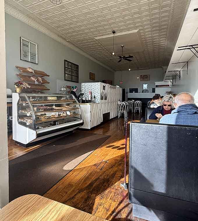 That tin ceiling and wooden floor combo creates the kind of atmosphere where good conversations happen over great food.