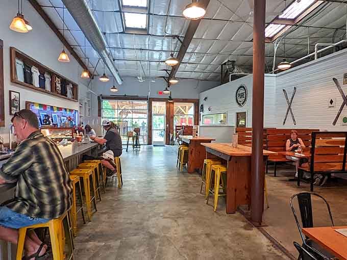 Industrial meets cozy in this light-filled space where yellow stools pop like sunshine against concrete floors.