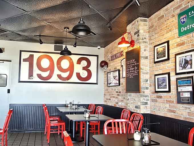 Exposed brick meets industrial chic where red chairs pop like cherries on a sundae of Motor City nostalgia.