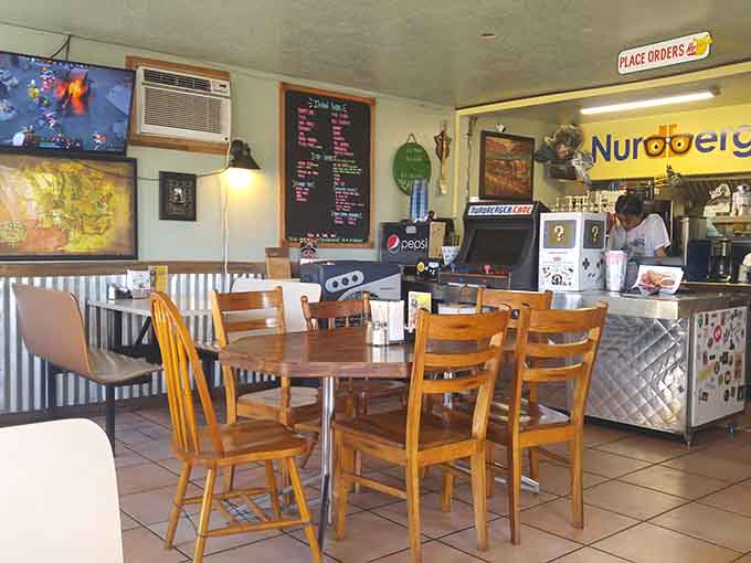 Gaming screens, mismatched chairs, and geeky decor create the perfect atmosphere for serious burger enjoyment.