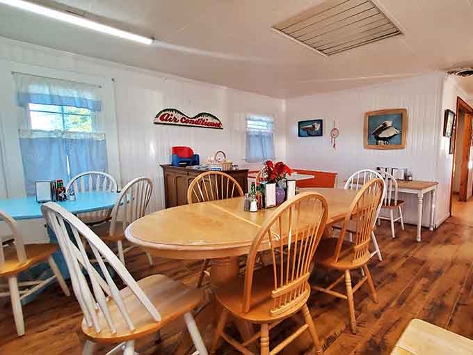 Mismatched chairs and coastal artwork create the kind of cozy dining room where strangers become friends over coffee.
