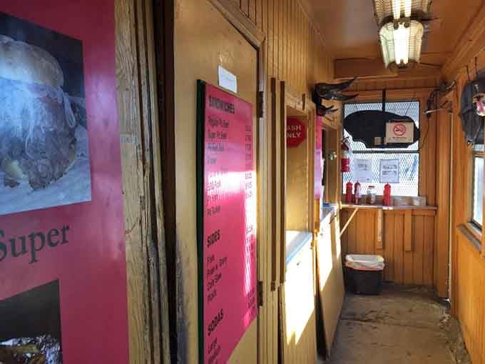 The cozy wood-paneled interior and bright pink menu boards create an atmosphere that's pure Baltimore roadside charm.