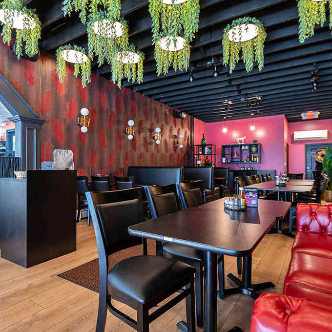 Hanging plants and warm lighting create an atmosphere where your stress checks out before you even order.