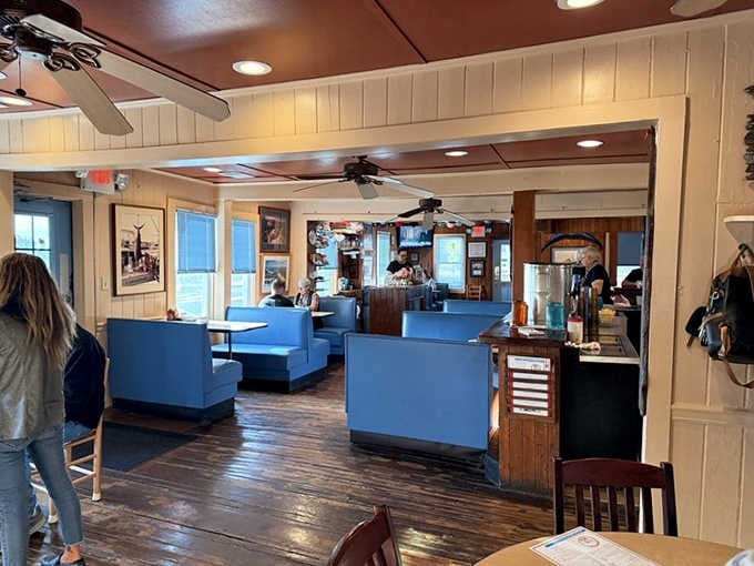 Blue booths and wooden tables creating that perfect casual atmosphere where everyone feels like a regular customer.