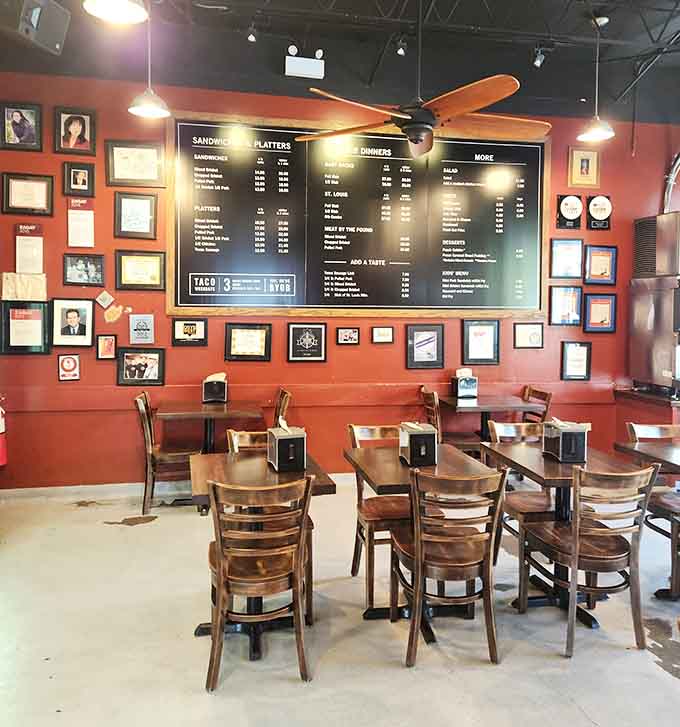 Framed memories line coral walls while simple tables await your feast, creating warmth without pretension or unnecessary fuss.