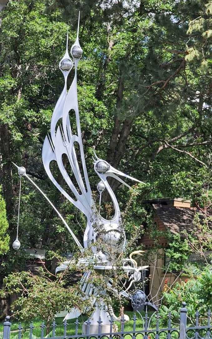 This graceful bird sculpture spreads its wings like it's about to take flight over the neighborhood.
