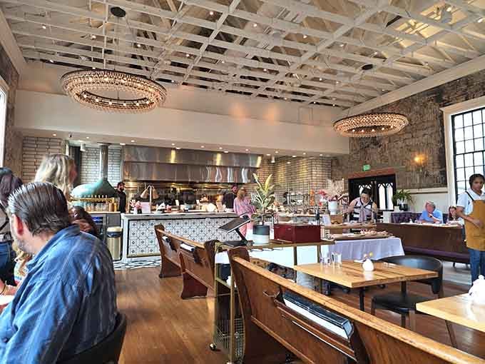 Exposed beams, sparkling chandeliers, and an open kitchen create an atmosphere that's farmhouse chic meets serious eating.