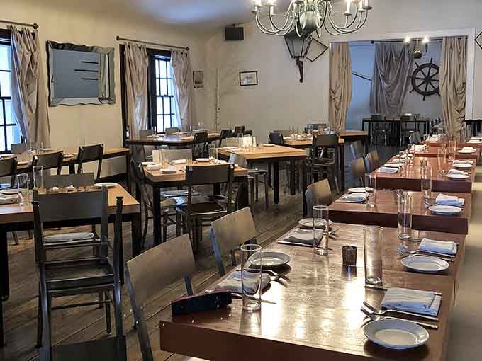 Nautical elegance meets Midwestern hospitality in a dining room where ship wheels and chandeliers create unexpected coastal magic.