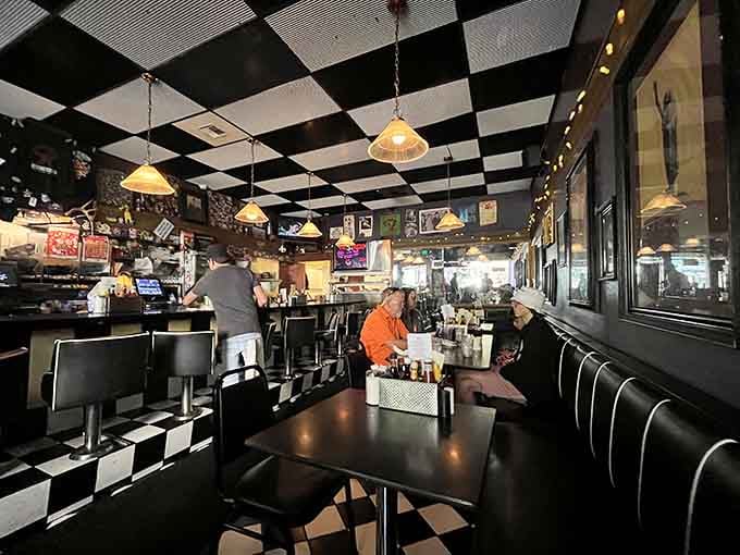 The checkered floor and vintage memorabilia create a time capsule you can actually eat in, wonderfully intact.