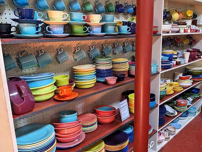 A rainbow of vintage ceramic dishware stacked like edible memories, each piece whispering stories from Sunday dinners past.