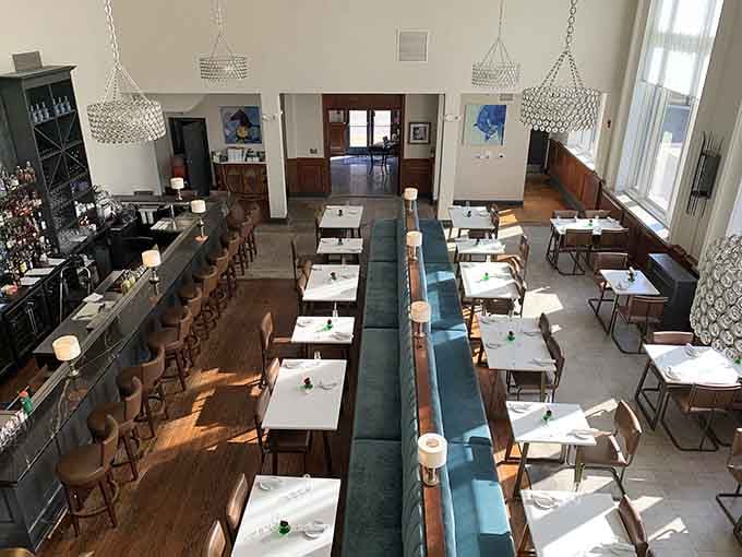 High ceilings and mid-century modern touches create a dining room that feels both grand and surprisingly intimate at once.