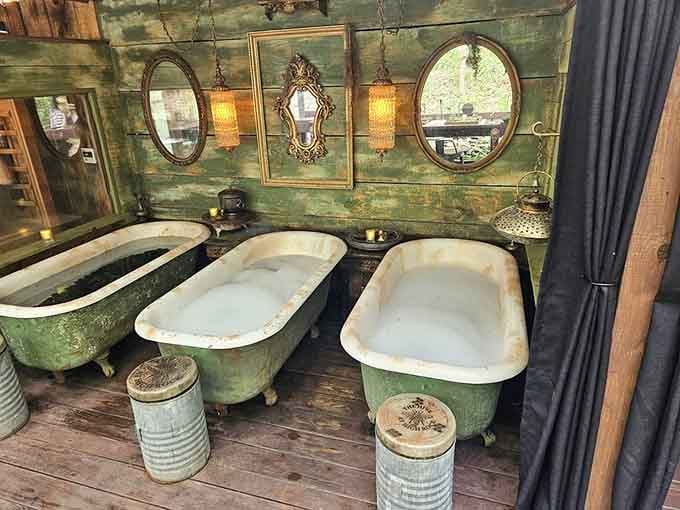 Vintage clawfoot tubs filled with bubbles under ornate mirrors create pure bathing magic in the woods.