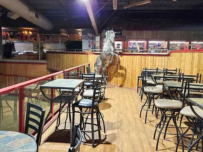 Inside, rustic charm meets serious comfort with wood paneling, horse art, and tables ready for feasting.