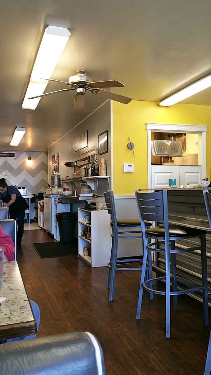 Yellow walls and counter seating create the kind of cozy atmosphere where strangers become friends over coffee refills.