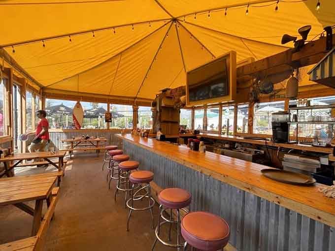 That corrugated metal bar wrapped in warm wood proves casual coastal dining doesn't need an ocean view.