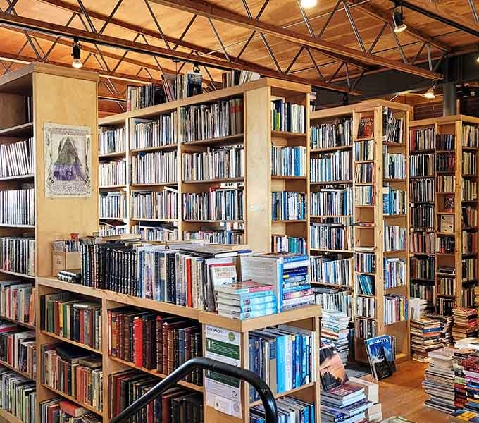 Village Books and Paper Dreams bookshelves reach toward exposed beam ceilings in a reader's dream come true.