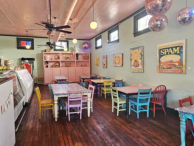 Mismatched chairs in every color create a dining room that feels like organized chaos done right.