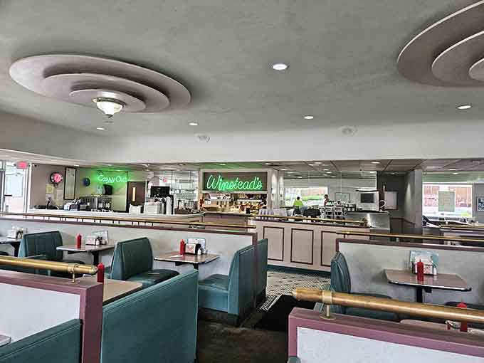 Those teal booths and circular ceiling details prove that some design choices are timeless, unlike your questionable haircut from 1987.