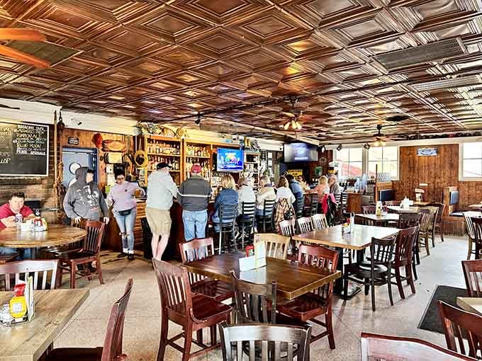 The tin ceiling gleams like a promise while wooden tables invite you to settle in for serious eating.
