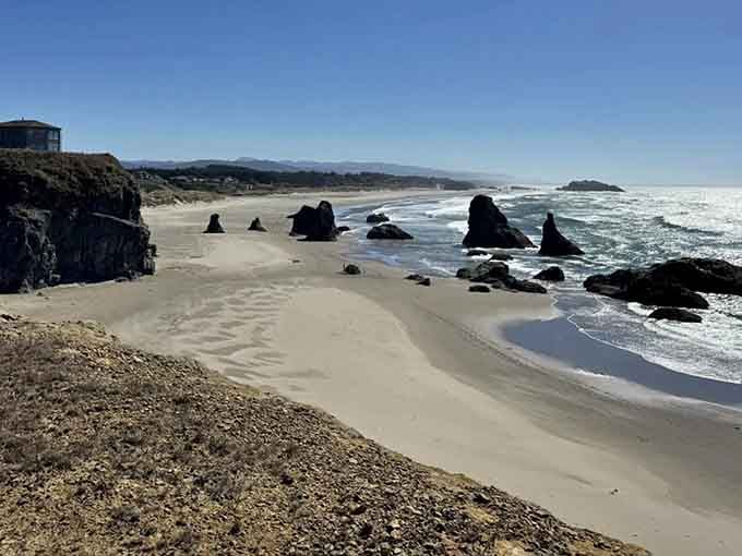 Sea stacks rise like ancient sentinels guarding this pristine beach, where waves whisper secrets to the sand.