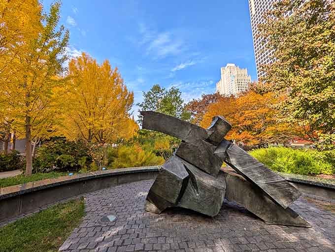 Fall foliage frames this angular metal sculpture perfectly, where downtown architecture meets contemporary art in stunning harmony.